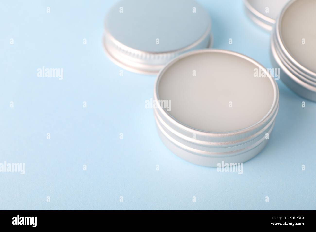 Lip balms on light blue background, closeup. Space for text Stock Photo ...