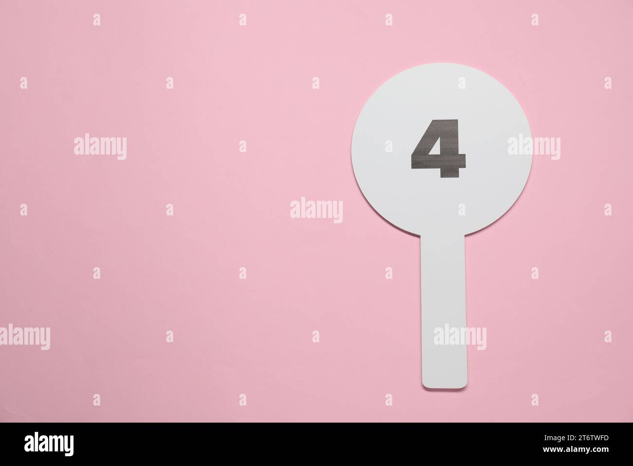 Auction paddle with number 4 on pink background, top view. Space for ...