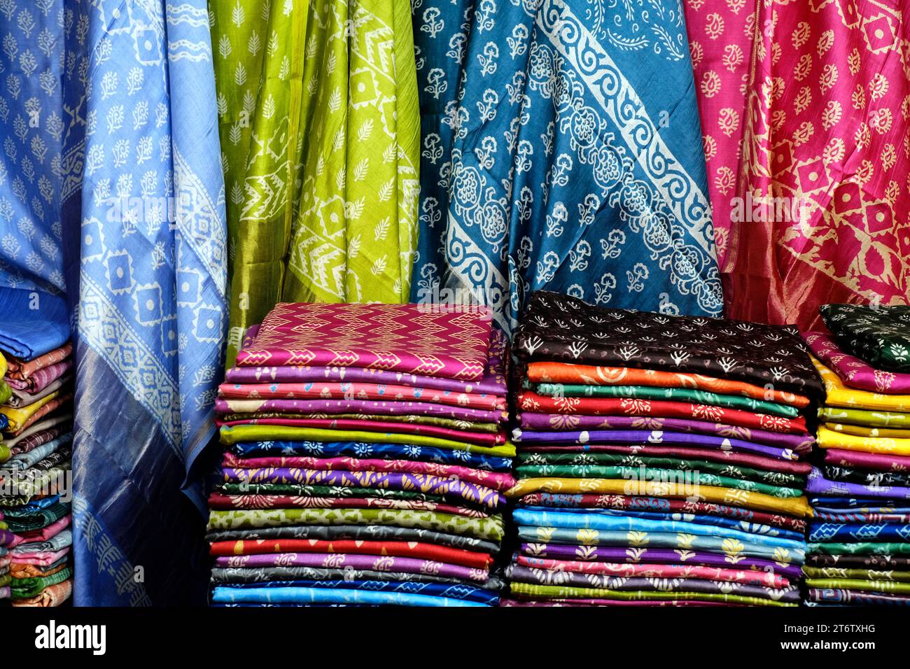 Fancy Indian sarees, Neatly stacked colorful silk saris in racks in a ...
