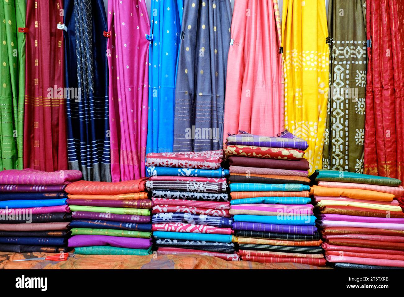 Fancy Indian sarees, Neatly stacked colorful silk saris in racks in a ...