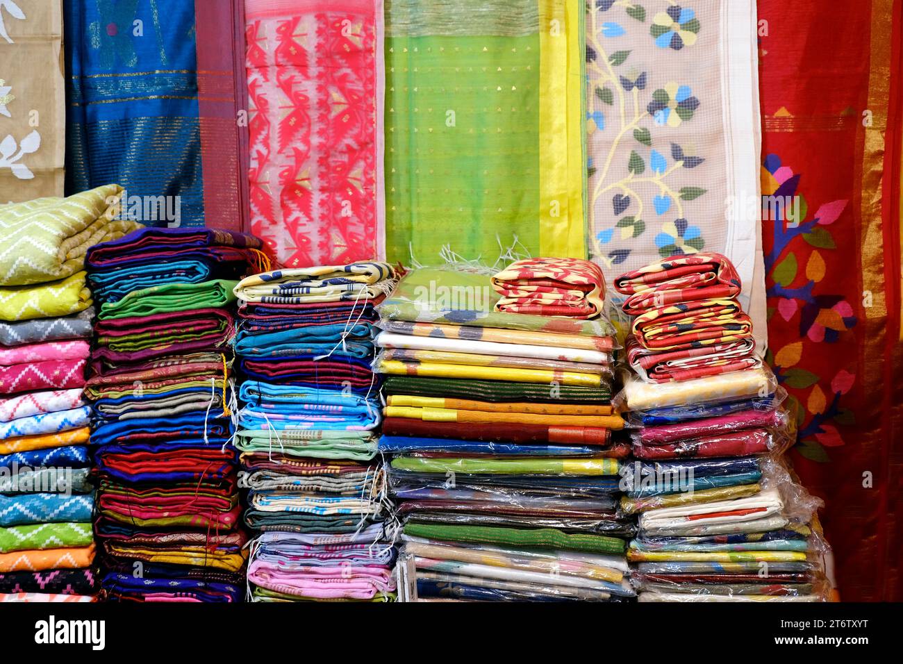 Fancy Indian sarees, Neatly stacked colorful silk saris in racks in a ...