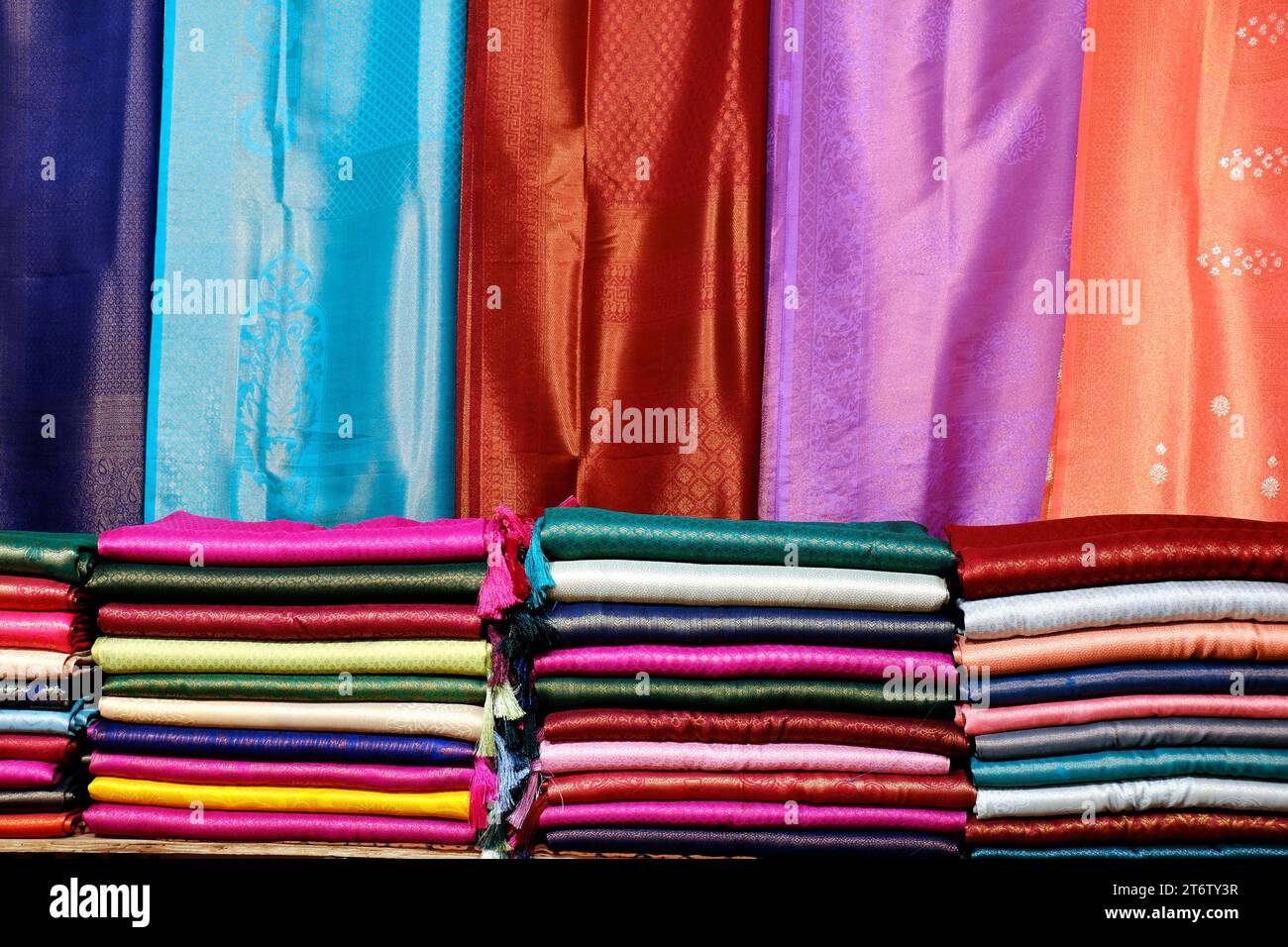 Fancy Indian sarees, Neatly stacked colorful silk saris in racks in a ...