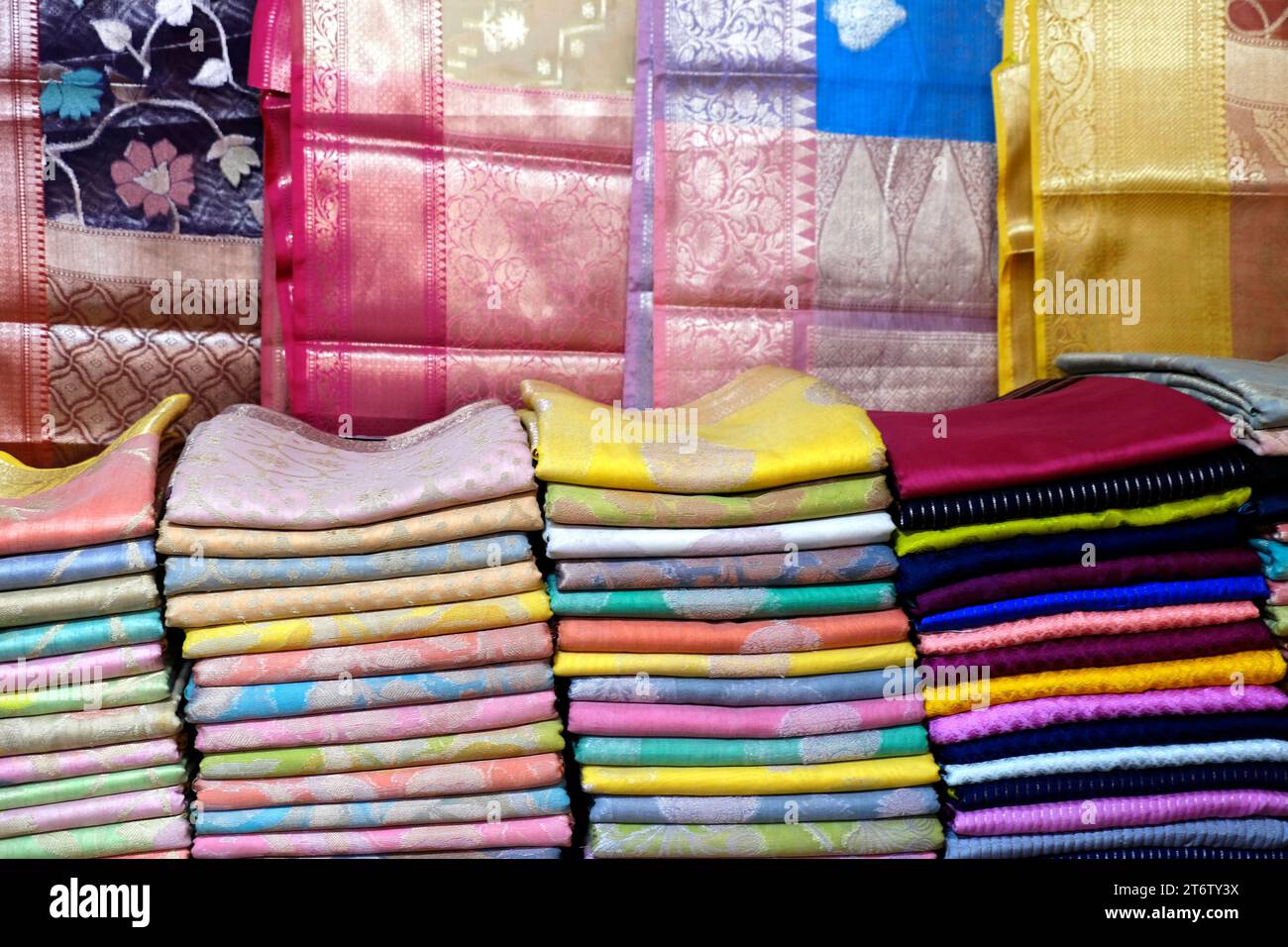 Fancy Indian sarees, Neatly stacked colorful silk saris in racks in a ...