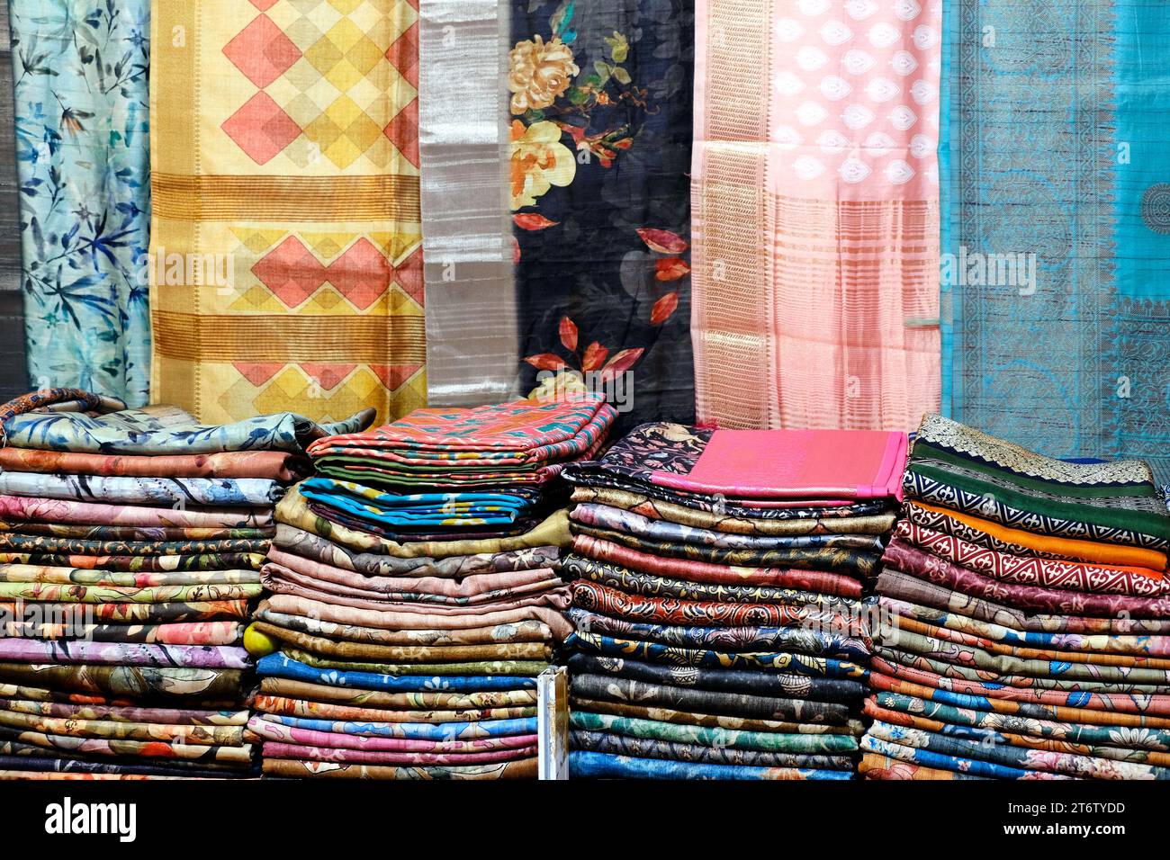 Fancy Indian sarees, Neatly stacked colorful silk saris in racks in a ...