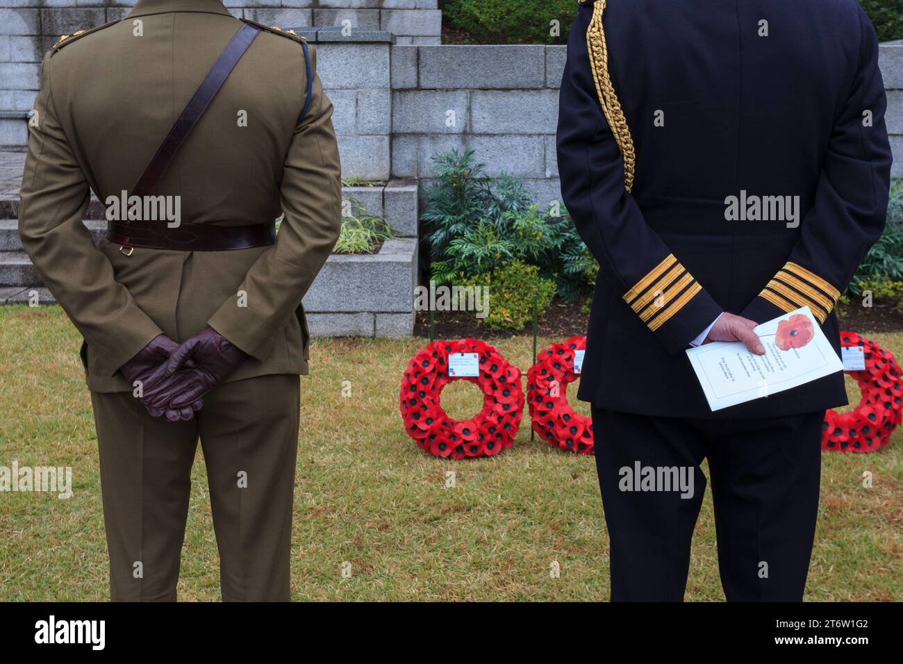 Men in military uniform hold a program for the Remembrance Sunday ...