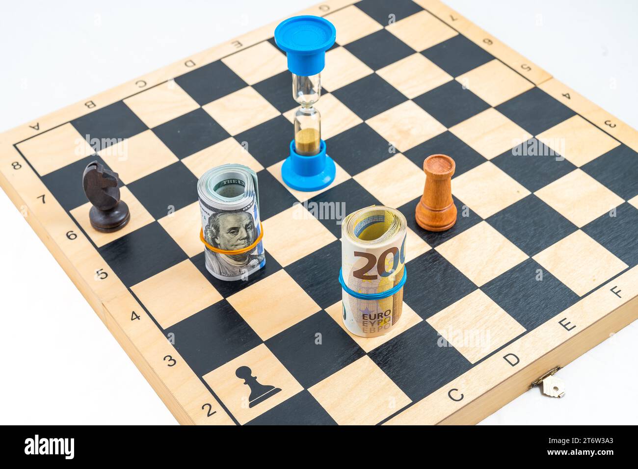Chess board with selected chess figures and rolled euro bank notes and ...