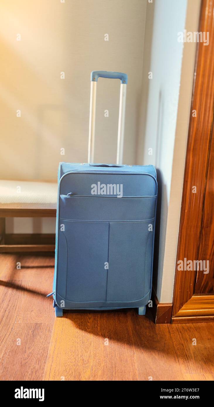 blue suitcase in a hotel room illuminated by the window light Stock ...