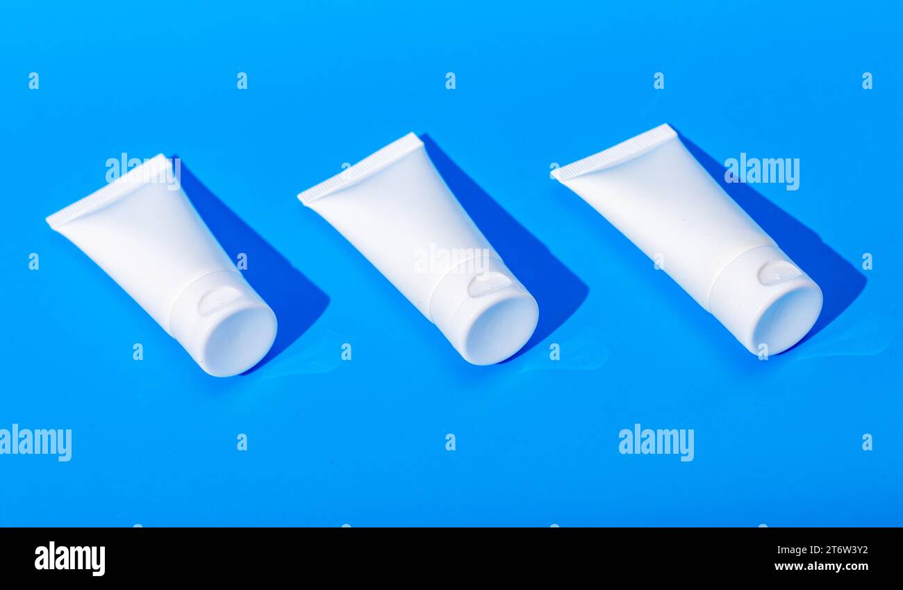 Cream tubes mockup row, three cosmetic product packages, blank white ...