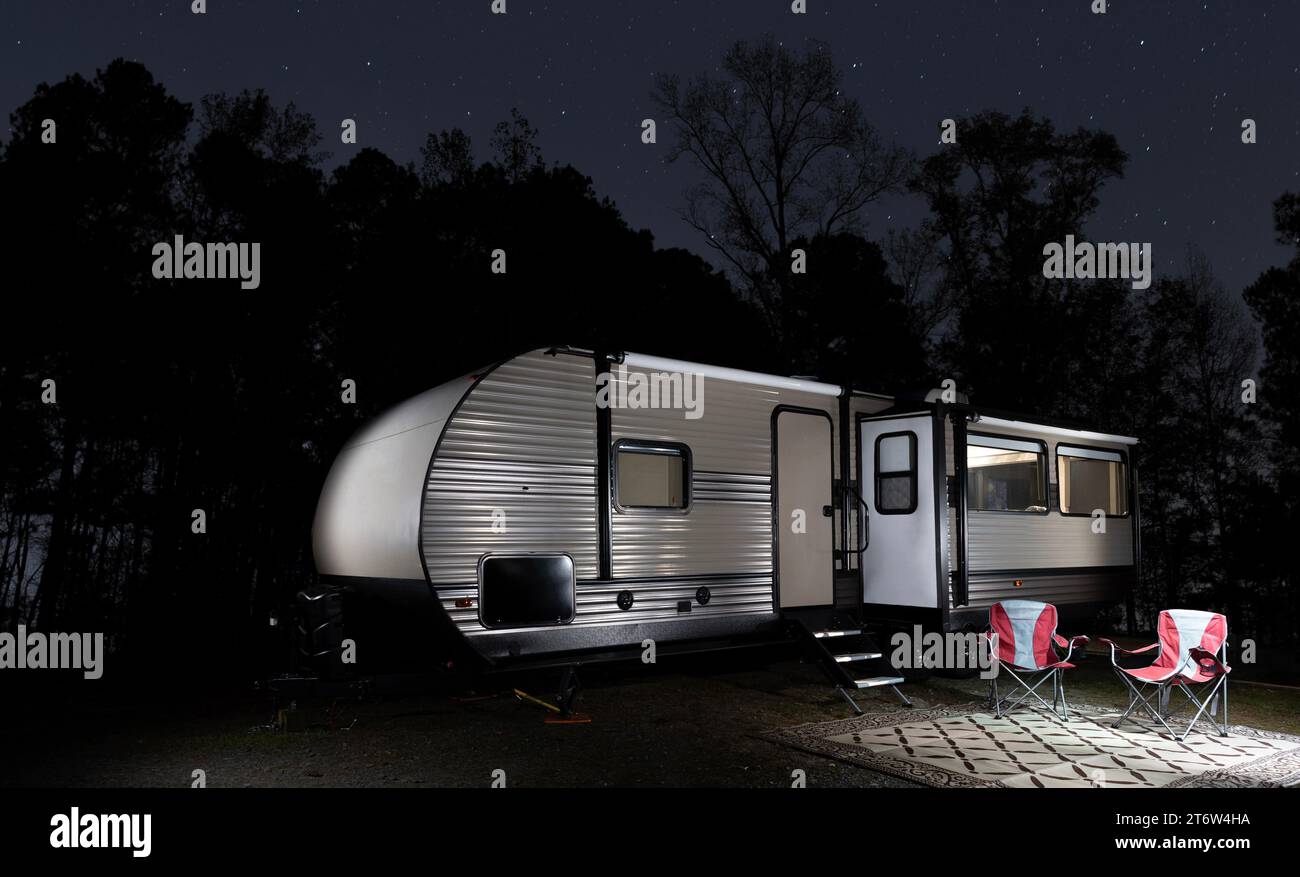 Star filled night at a remote campsite with an RV with its lights on ...