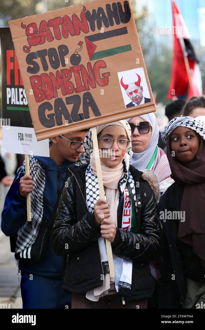 A protester carries a placard saying ’Satanyahu, Stop Bombing Gaza’ as ...