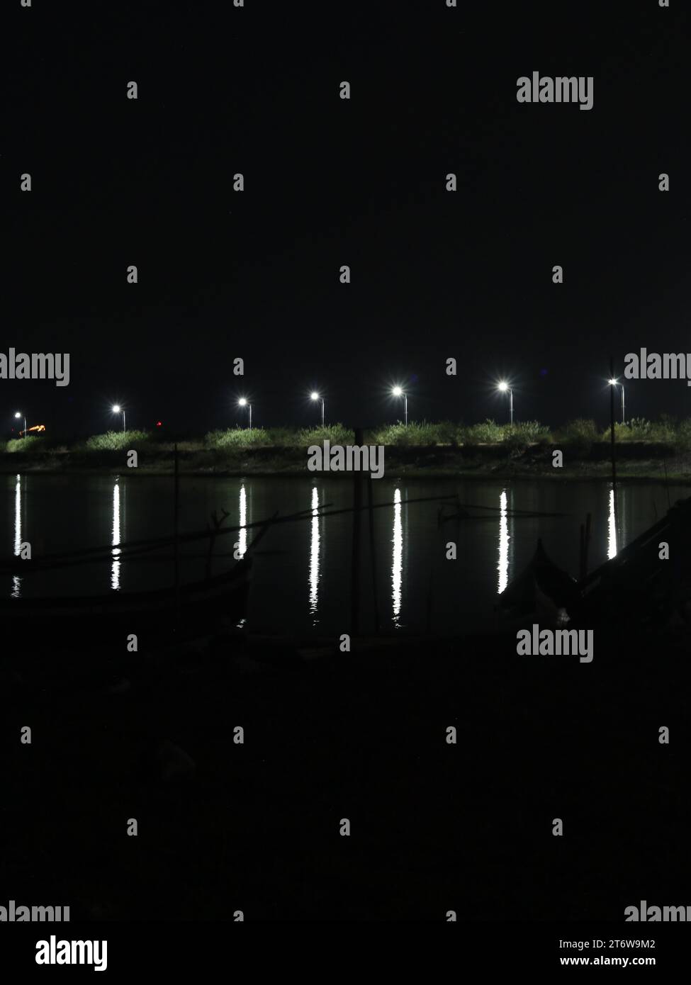 deserted street at night. row of street lights on the edge of Lake ...