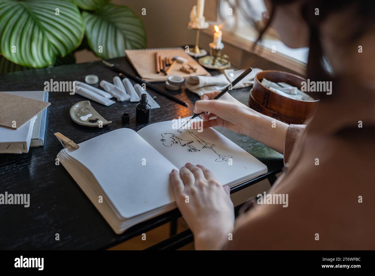 Workplace of cartoon illustrator drawing in sketch book with ink ...