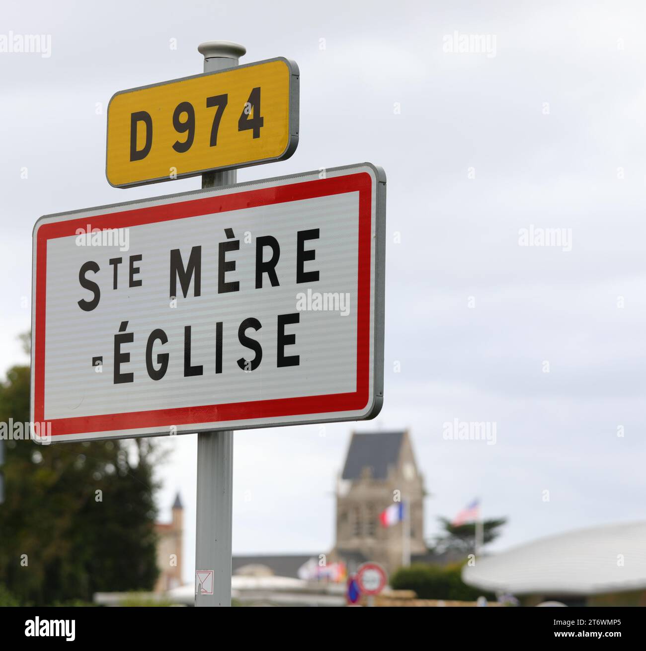 road sign with name of place and the church and bell tower which became ...