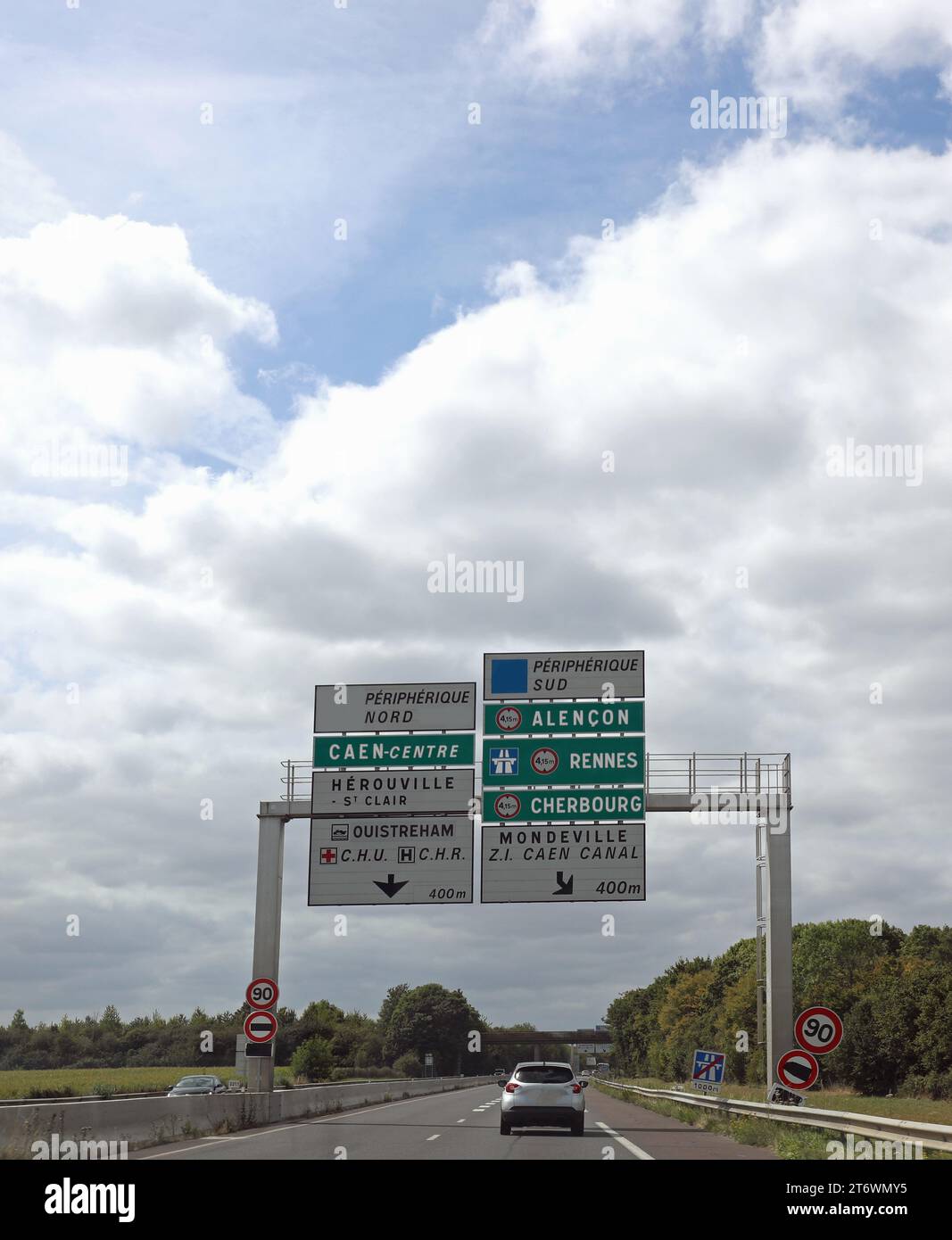 large road sign with the French locations to go to the city of Caen or ...