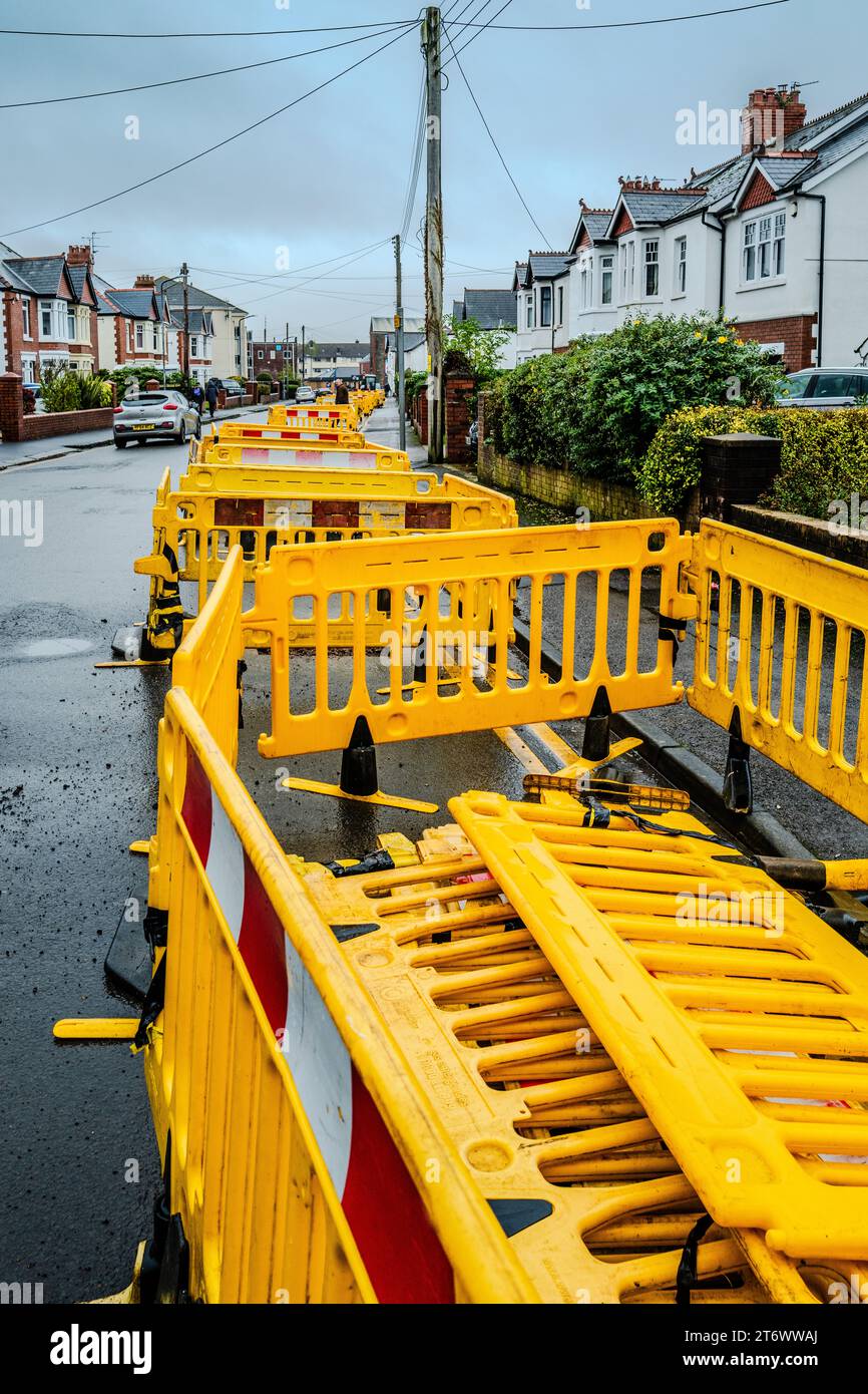 Pipe laying roadworks in Cardiff. Bright yellow safety barriers protect ...