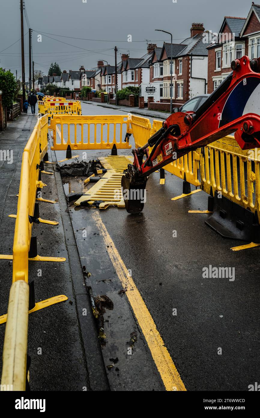 Pipe laying roadworks in Cardiff. Bright yellow safety barriers protect ...