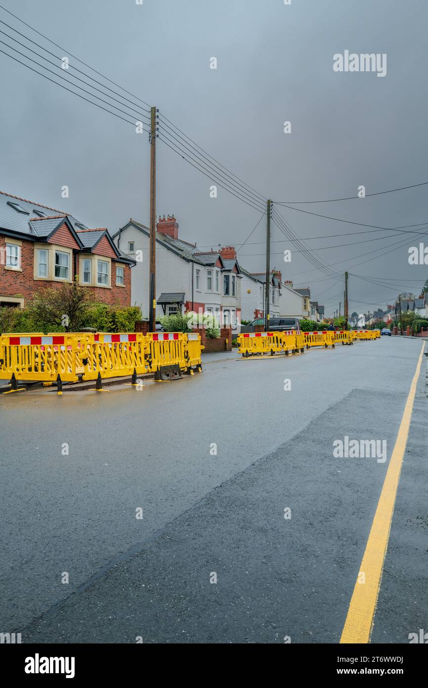 Pipe laying roadworks in Cardiff. Bright yellow safety barriers protect ...