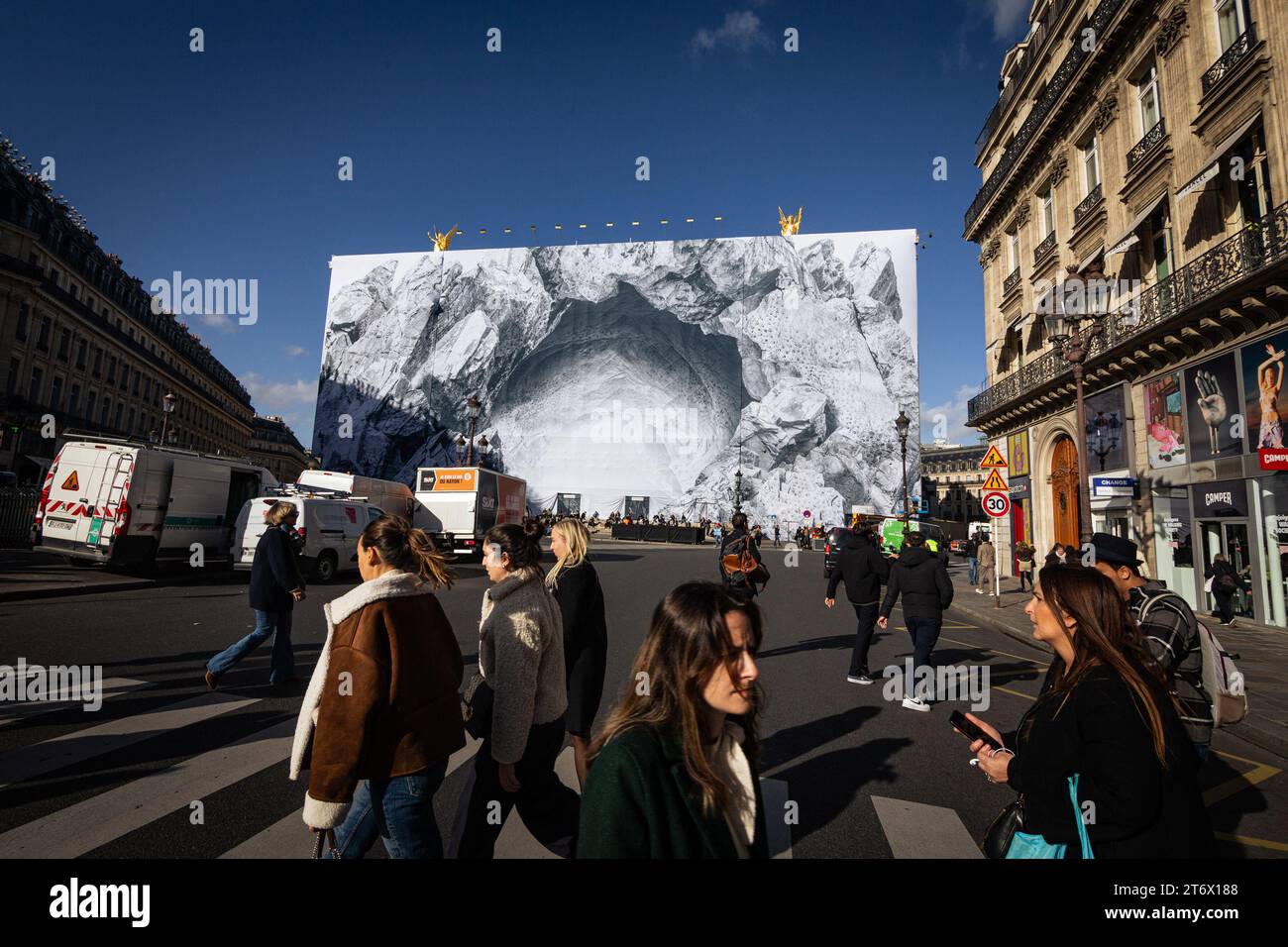 People seen passing in front of Opera Garnier with facade of JR artwork ...