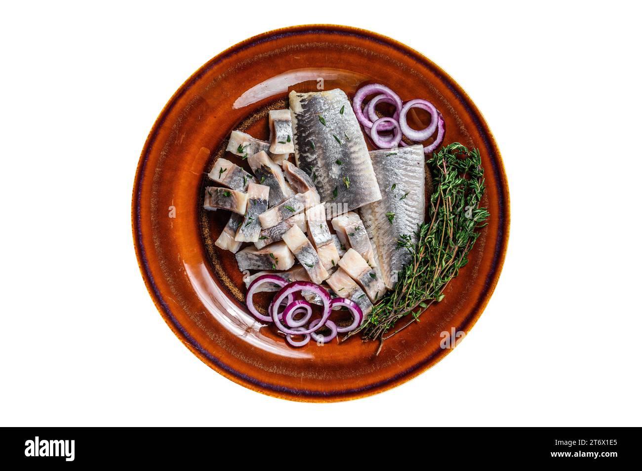 Pickled marinated herring fish sliced fillet on a plate with thyme and ...