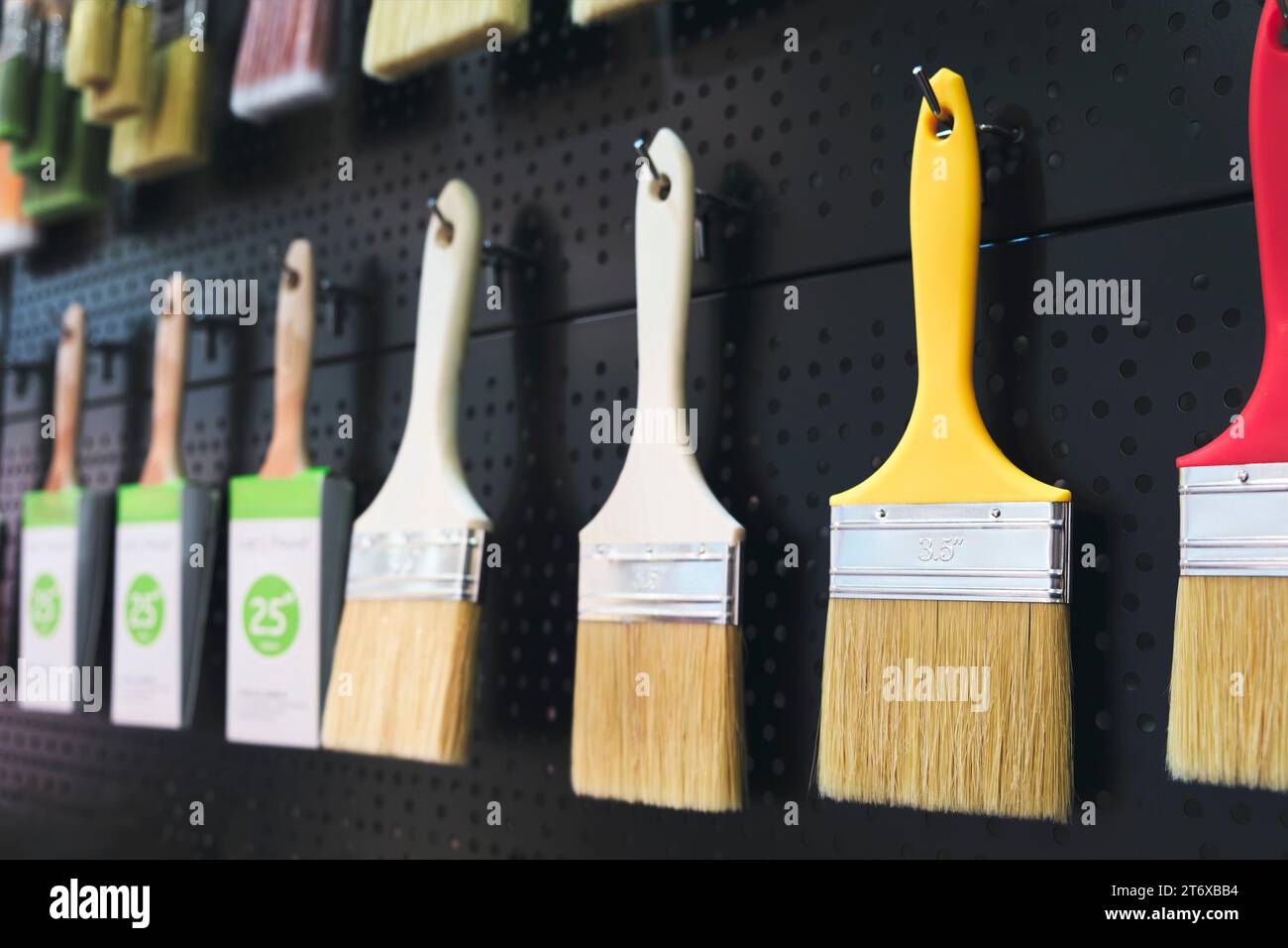 Multi-colored brushes for repairing black wall painting hang on a stand ...