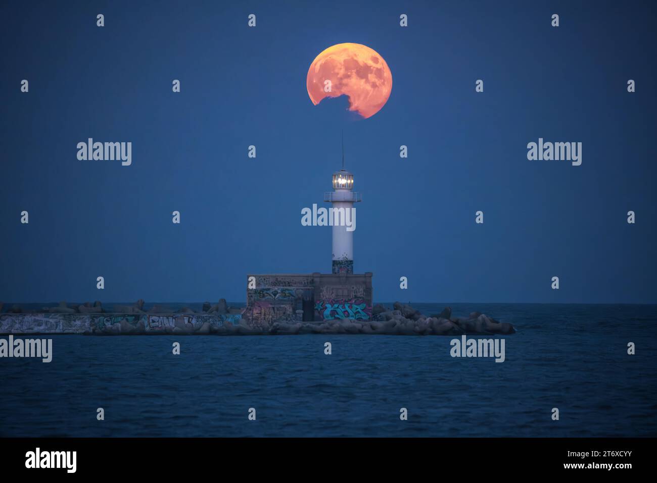 Full moon twilight landscape over sea horizon and lighting lighthouse ...