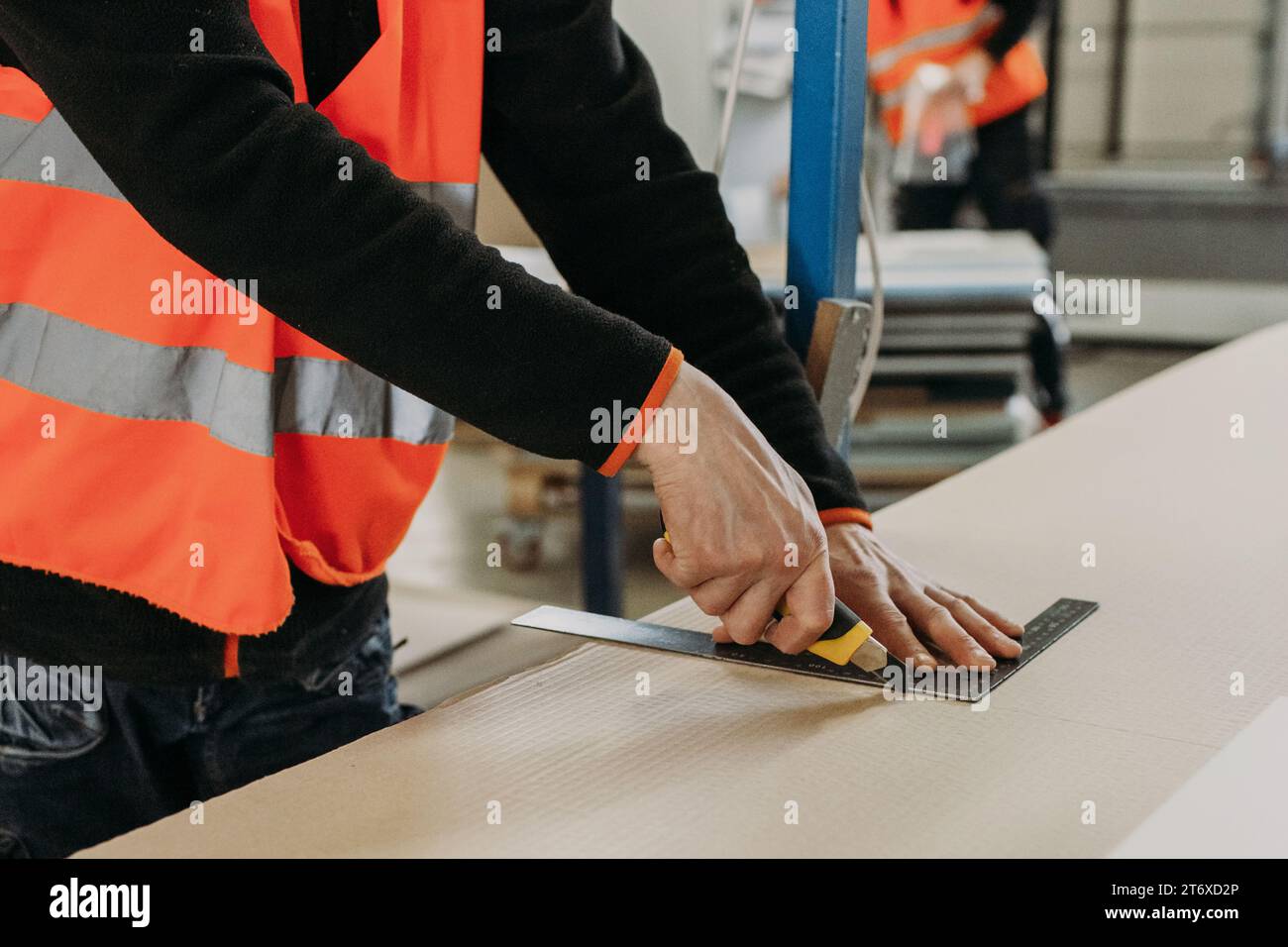 Worker cutting cardboard with utility knife and ruler, closeup Stock ...