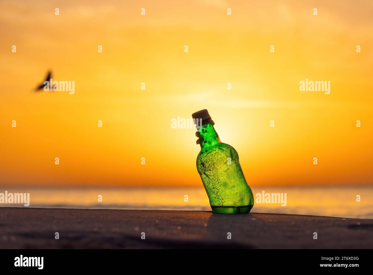 Sea sunrise and alcohol bottle on the beach sand, travel destination ...