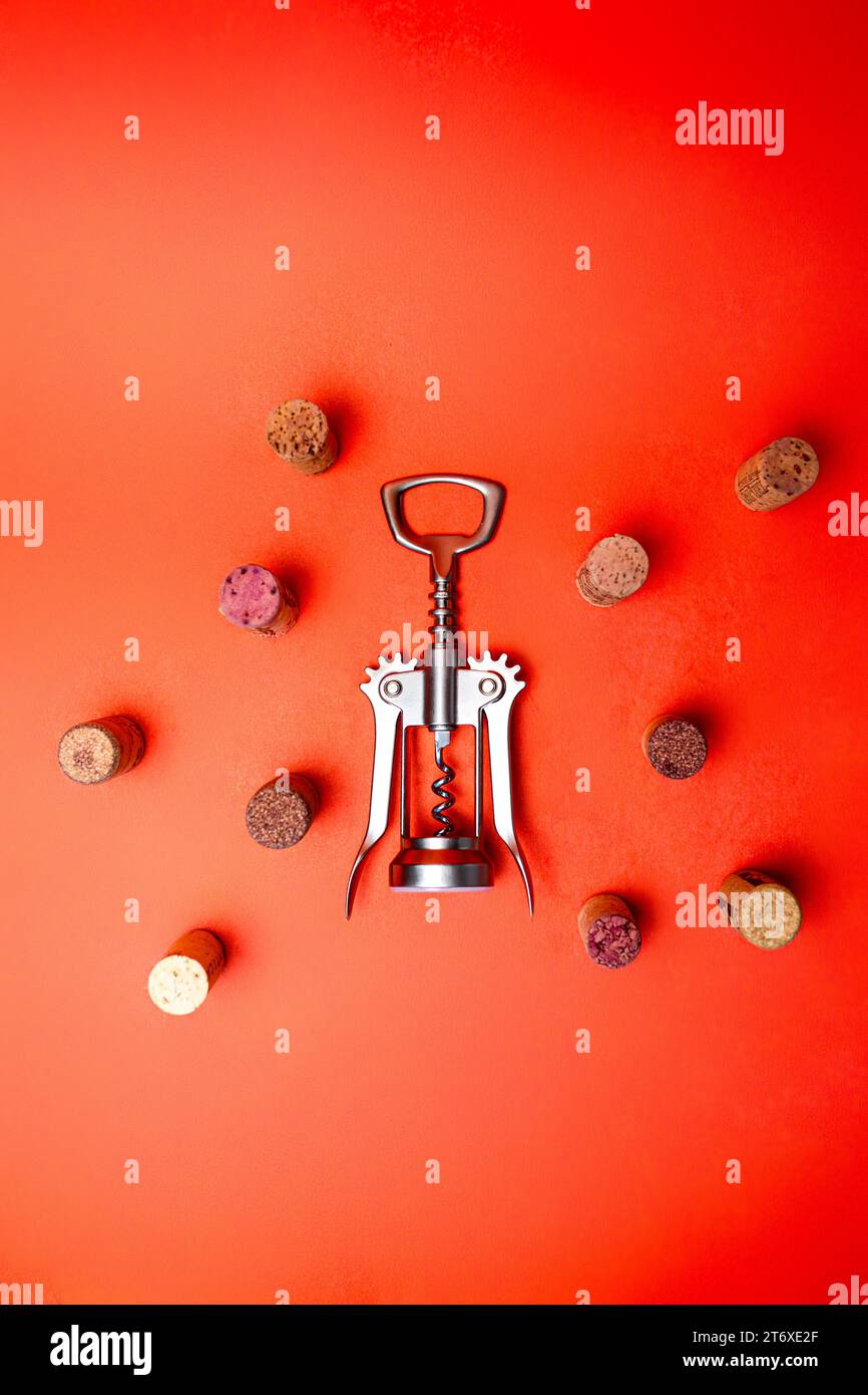 top view of a metal corkscrew with wine corks on a red background Stock ...