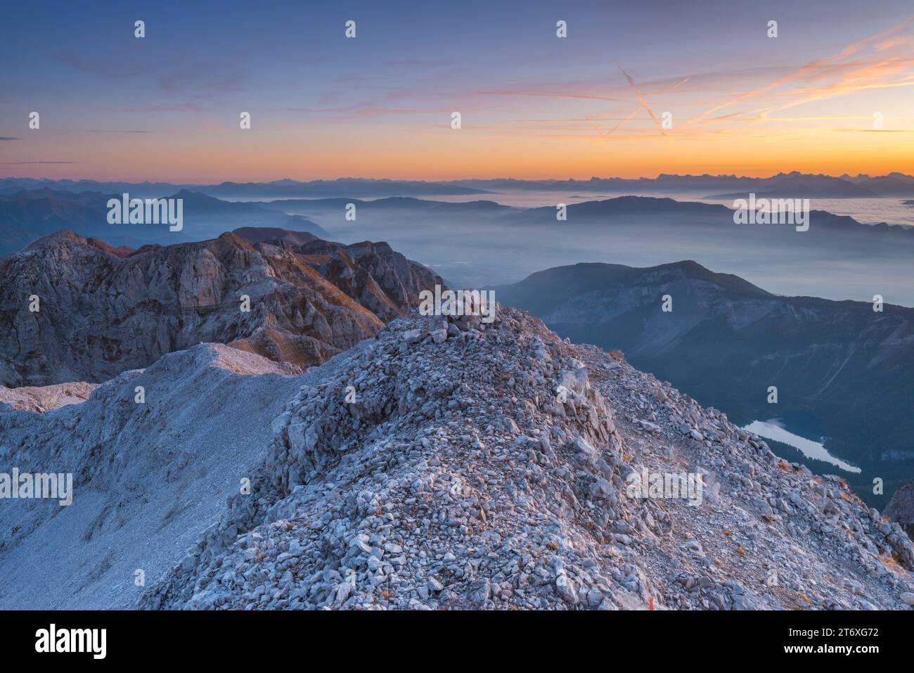 First sunlight hitting the rocky mountain slopes with lake Tovel and ...
