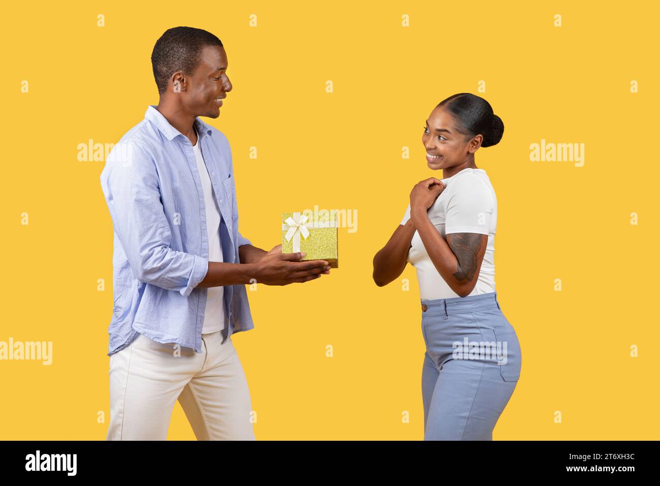 Black man giving woman gift, both happy Stock Photo - Alamy