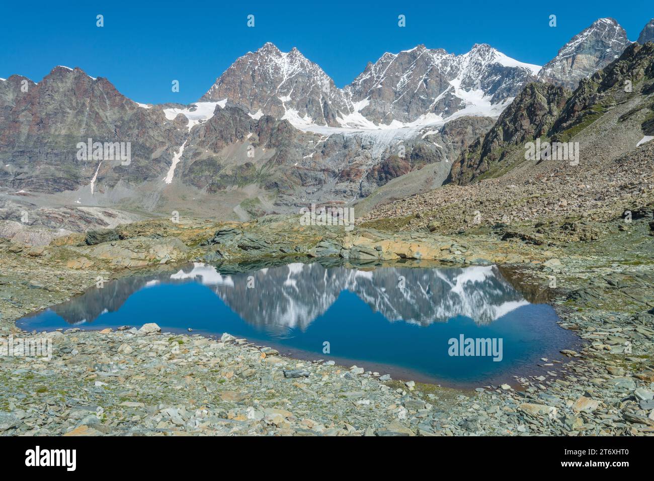 Peaks of the Italian Alps in the Bernina group are mirrored in a small ...