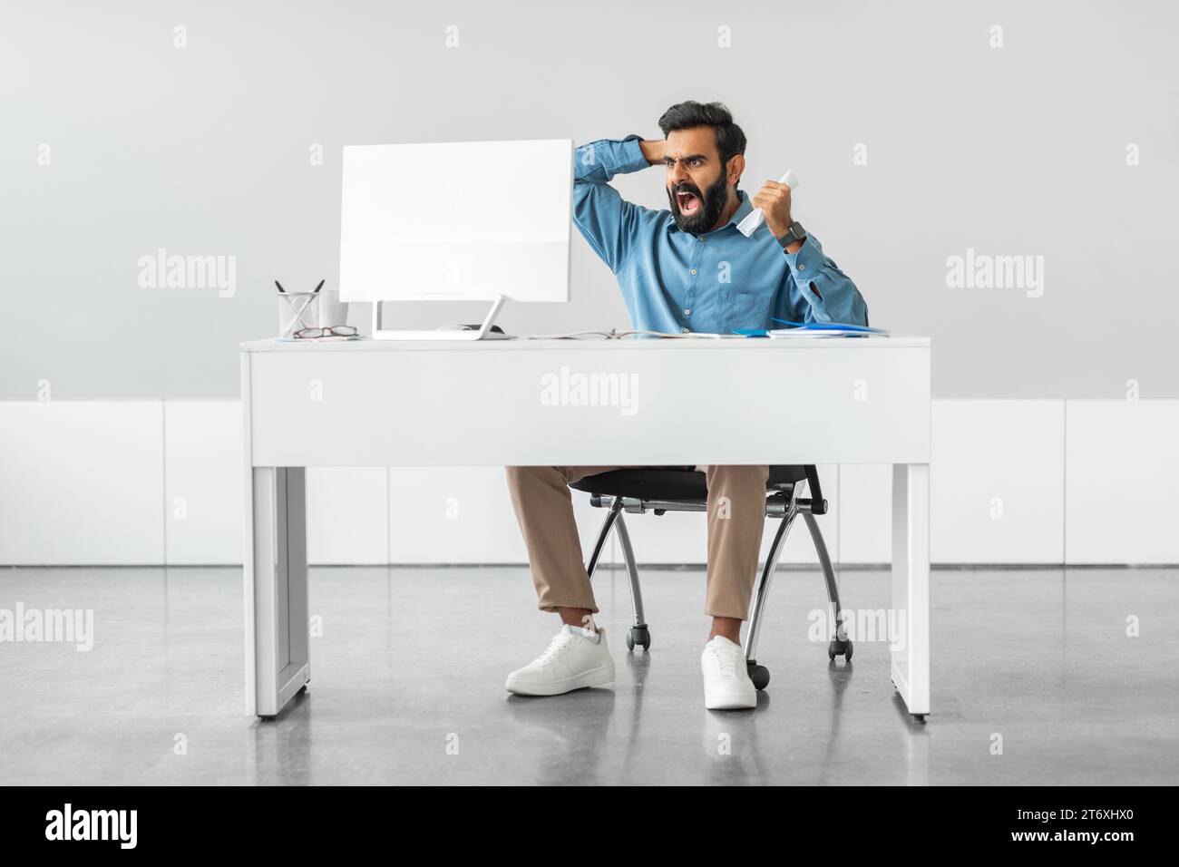 Frustrated indian man yelling at computer in office Stock Photo - Alamy