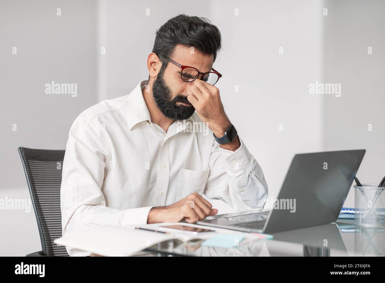 Stressed indian businessman at desk with laptop Stock Photo - Alamy