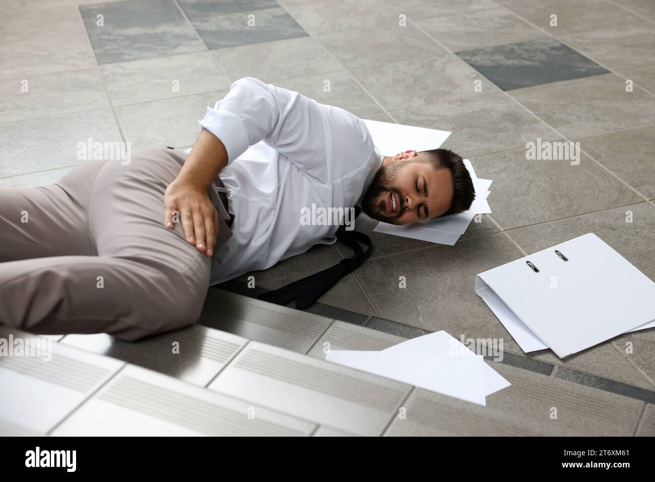 Man fallen down stairs suffering from pain indoors Stock Photo - Alamy