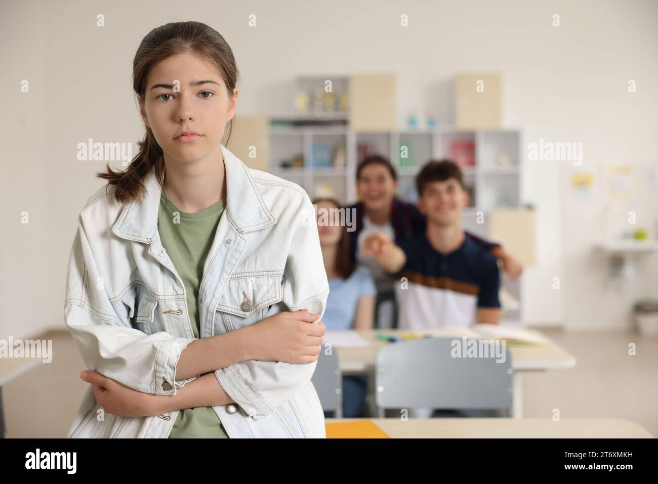 Teen problems. Lonely girl standing separately from other students in ...