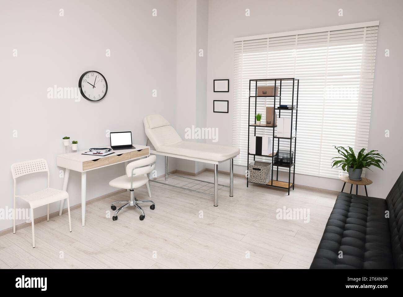 Modern medical office with doctor's workplace and examination table in ...