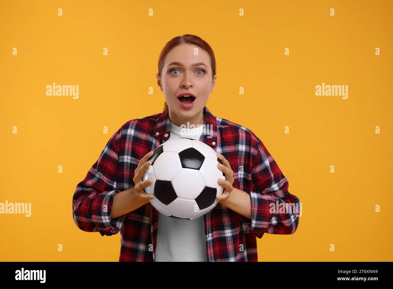 Emotional fan holding football ball on yellow background Stock Photo ...