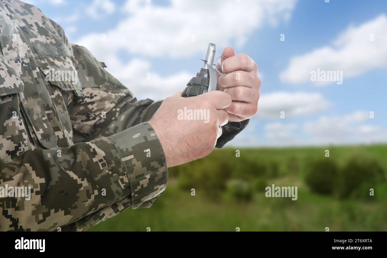 Soldier pulling safety pin out of hand grenade outdoors, closeup Stock ...
