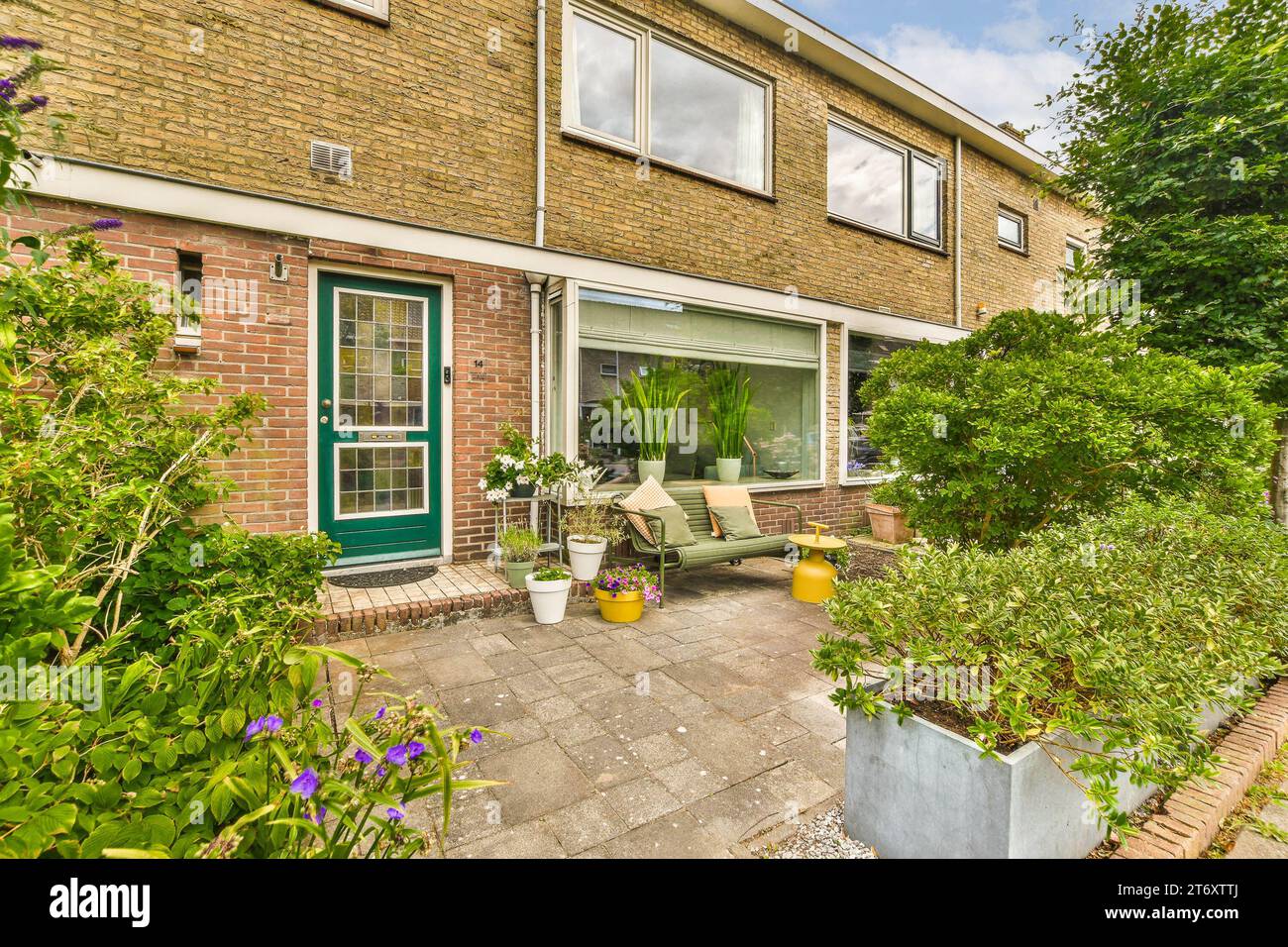 an outside area with plants and flowers in the fore - windowed corner ...