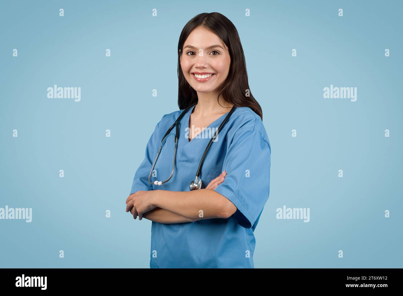 Smiling young female nurse with arms crossed Stock Photo - Alamy