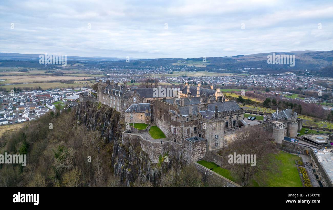 A majestic castle stands tall on a cliff edge, with several buildings ...