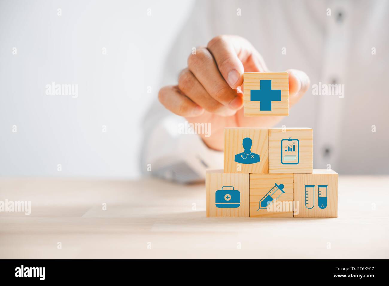 Hand hold wooden block with icon healthcare medical Stock Photo - Alamy