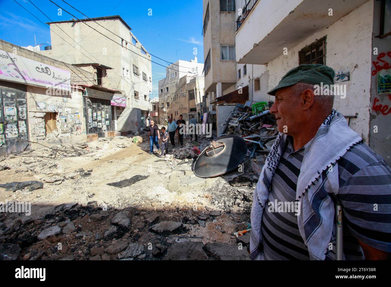 Palestinians inspect damaged buildings after an Israeli military raid ...
