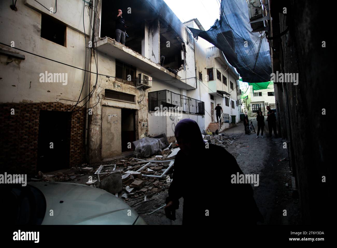 Palestinians inspect damaged buildings after an Israeli military raid ...