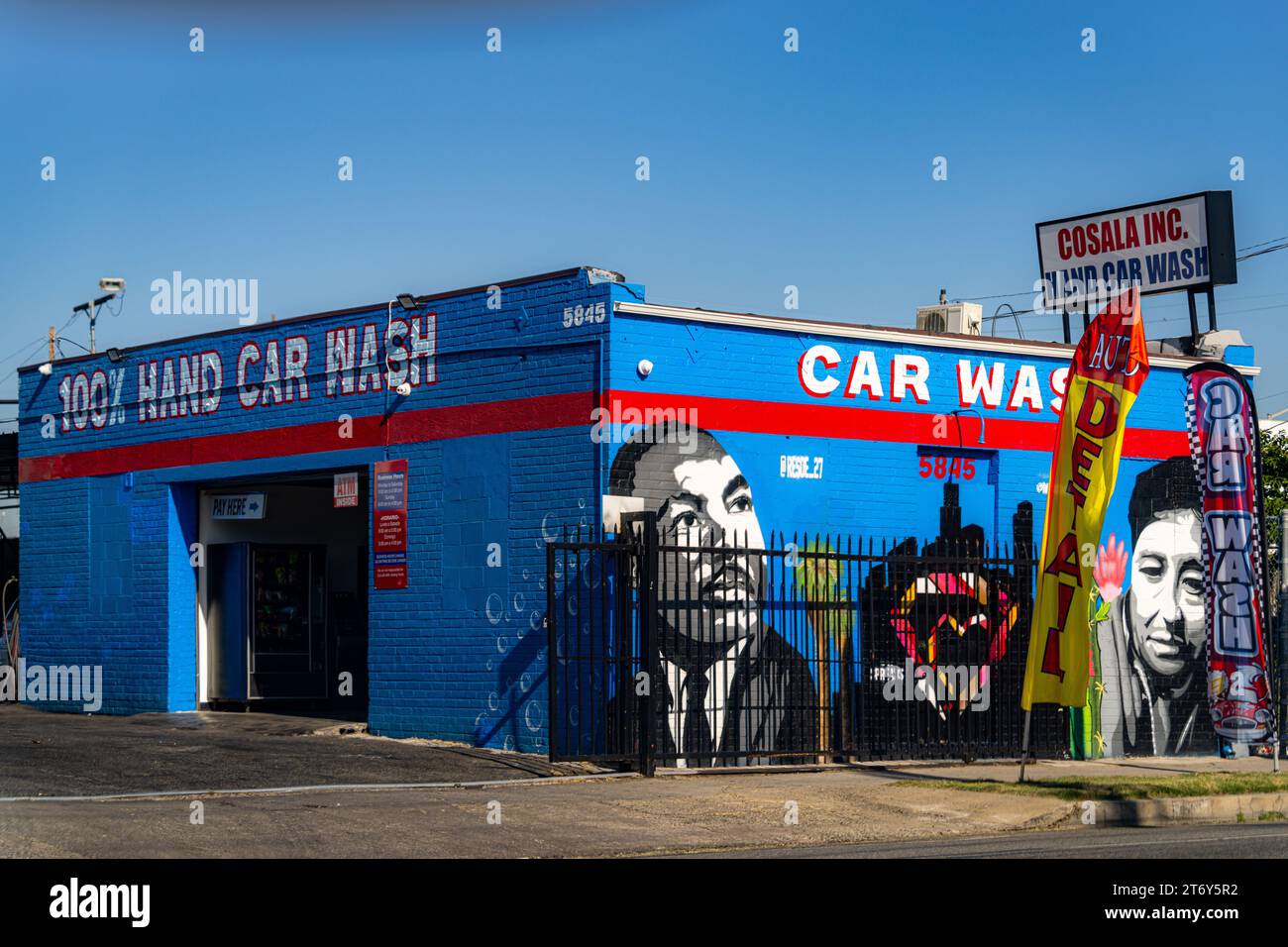 This stock image shows a blue car wash with a graffiti mural decorating ...