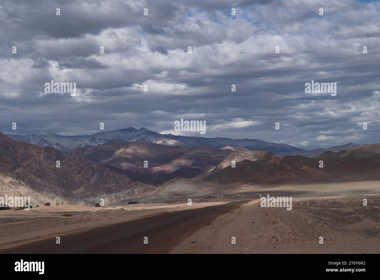A desolate dirt road stretches across a barren desert landscape ...