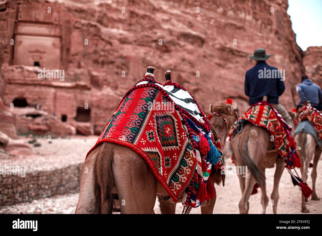 Tourists riding camels ride along the Siq Canyon and explore the ...