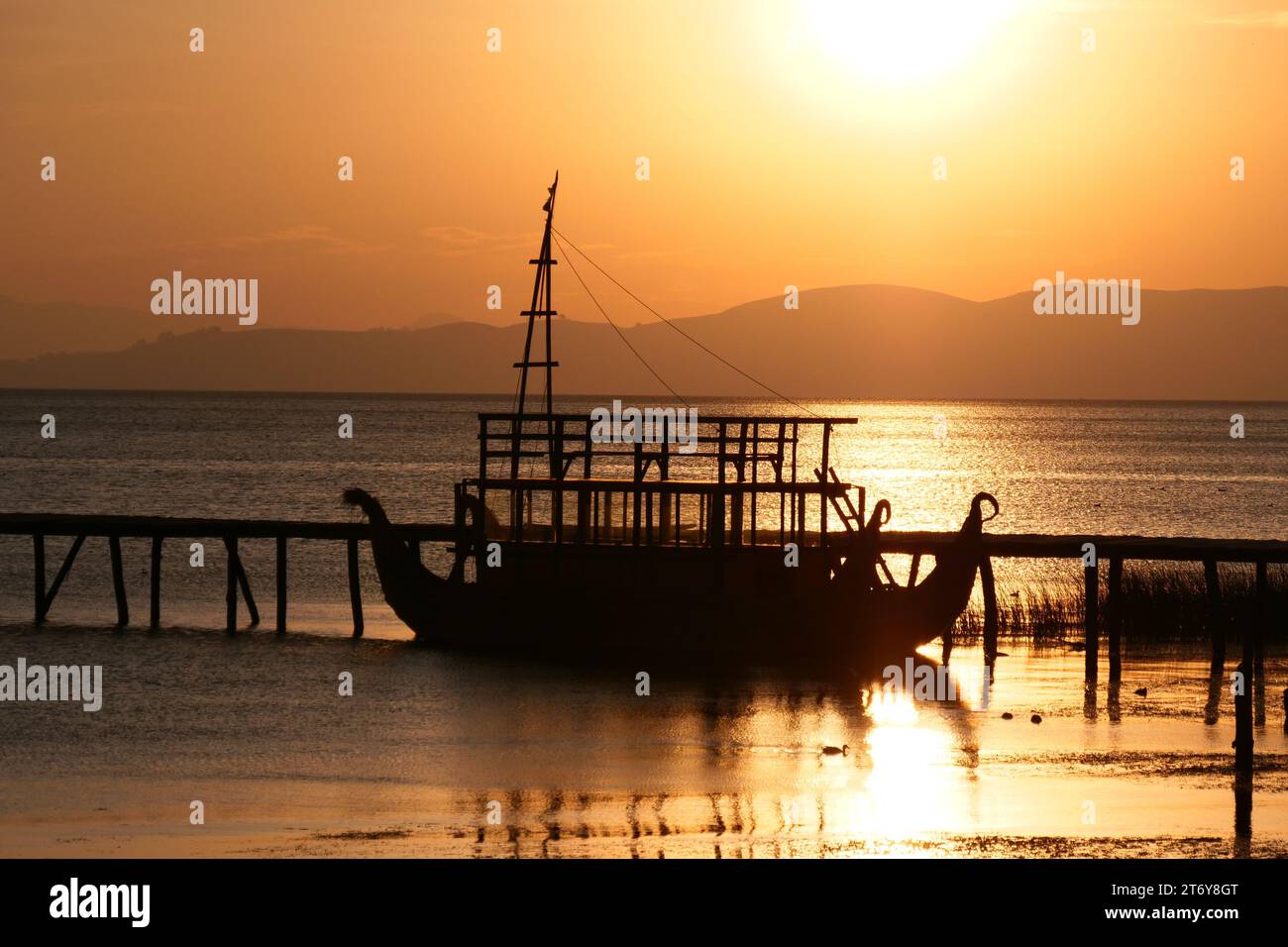 Traditional reed boat on lake Titicaca, Bolivia, with sunsetting on the ...