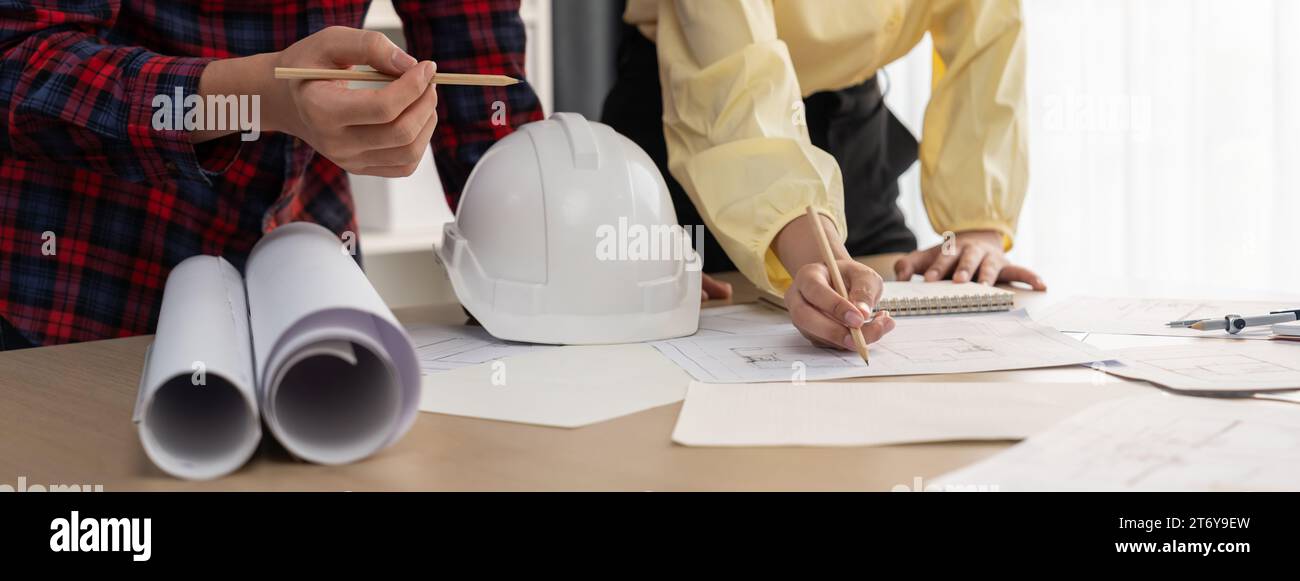 Professional engineer draws a blueprint on meeting table with blueprint ...