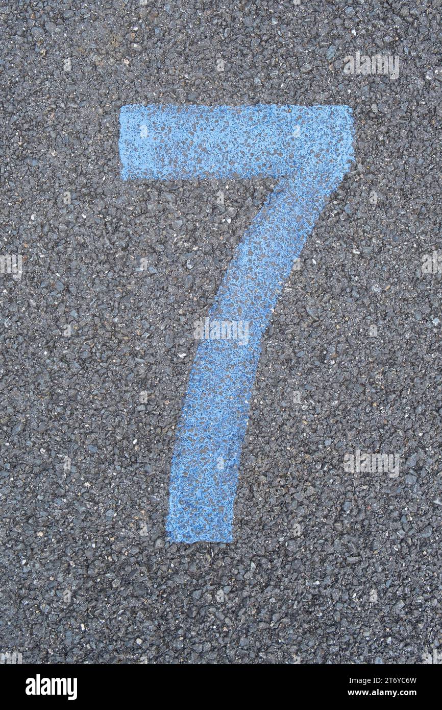 the number 7 seven are drawn with color paint on asphalt. a children's ...